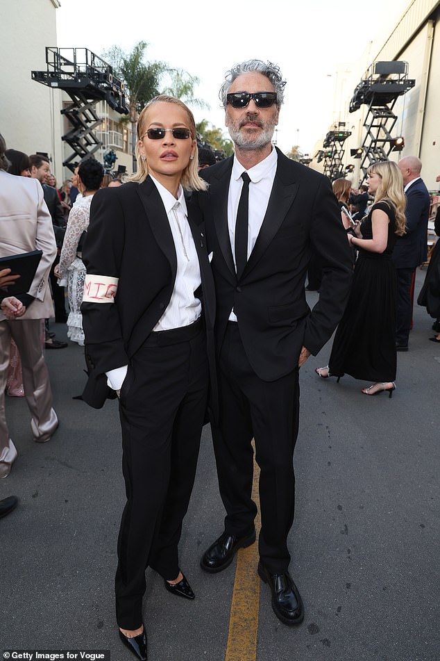 Rita Ora matches her husband Taika Waititi in black suits at the Vogue ...