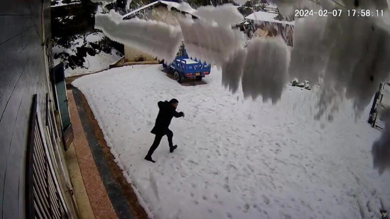 CCTV shows man’s lucky escape as huge sheet of snow crashes from roof