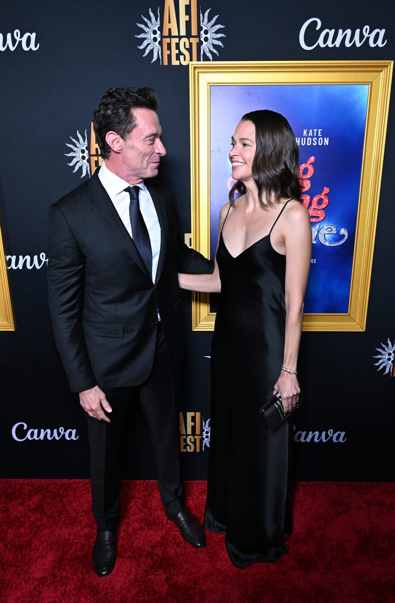 Hugh Jackman and Sutton Foster smile and hold hands during a beach date ...