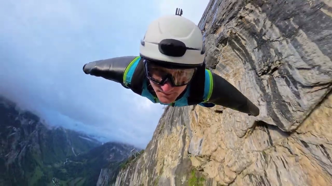 Man jumps from a cliff in a low ultimate two-way wingsuit base dive.