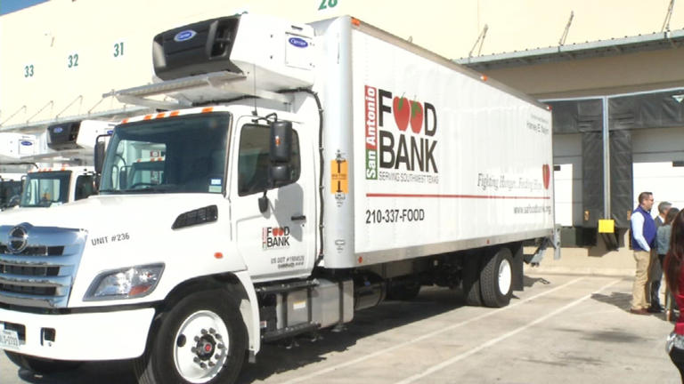 Harvey E. Najim helps stock shelves after committing $500,000 to San ...