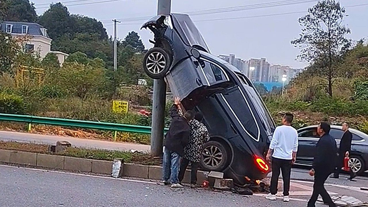 Car ends up stuck vertically on pole after high-speed crash