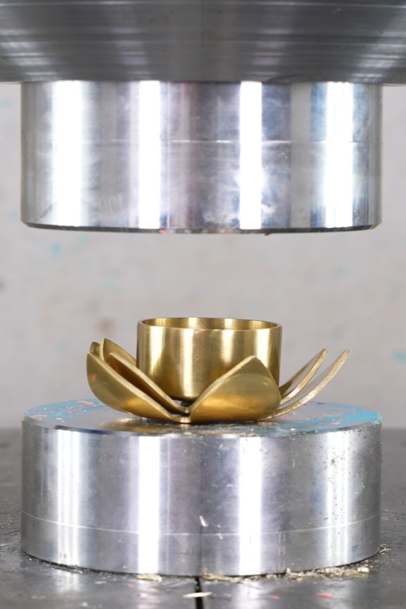 Golden candle holder under hydraulic press
