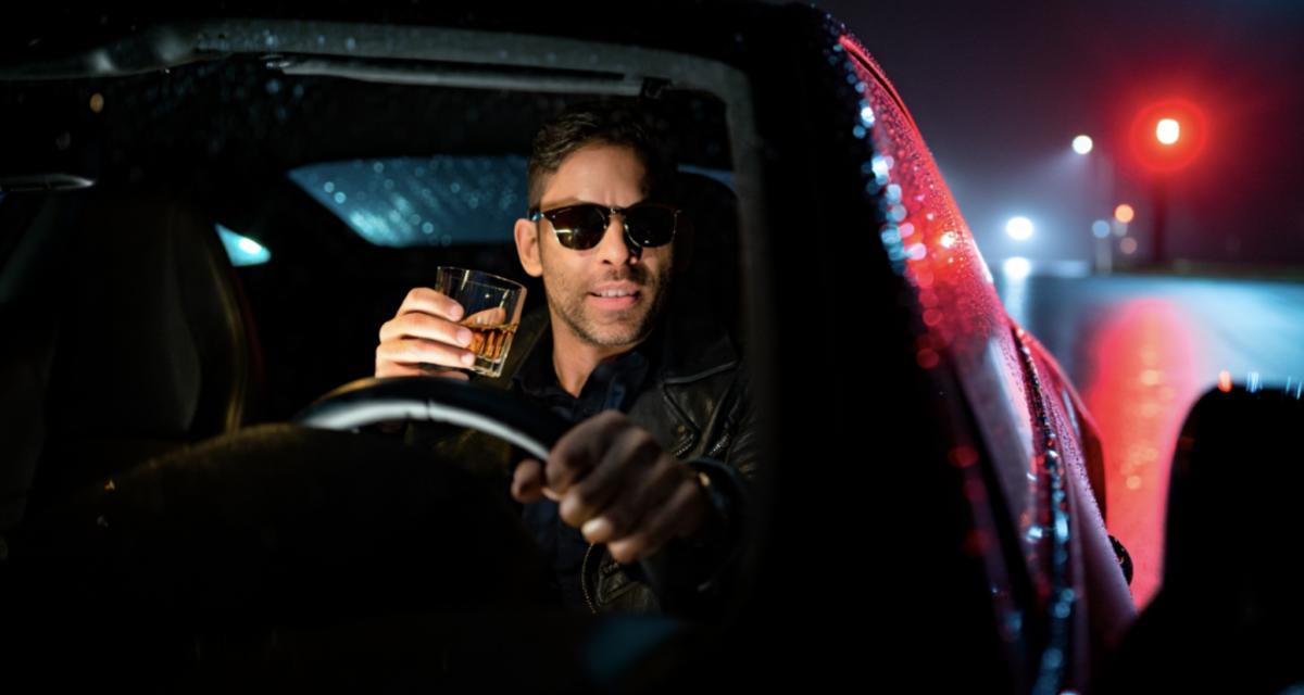 Il grille un feu rouge... avec un verre de whisky à la main