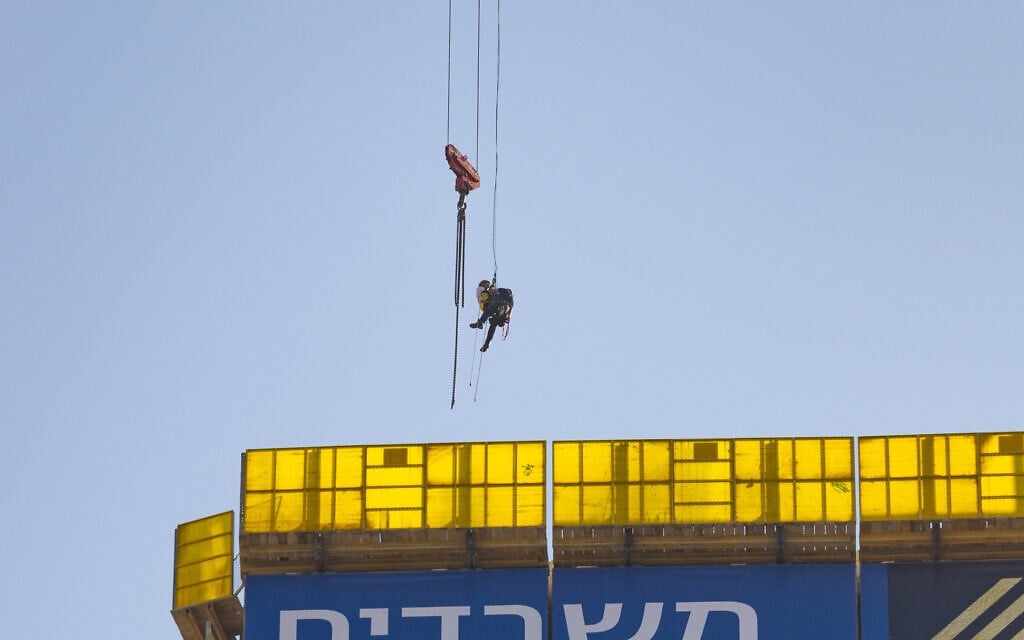 Teenage boy rescued from small platform hanging from crane over Jerusalem high-rise