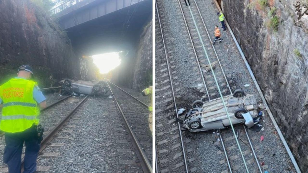 Chaos after car crashes onto train tracks