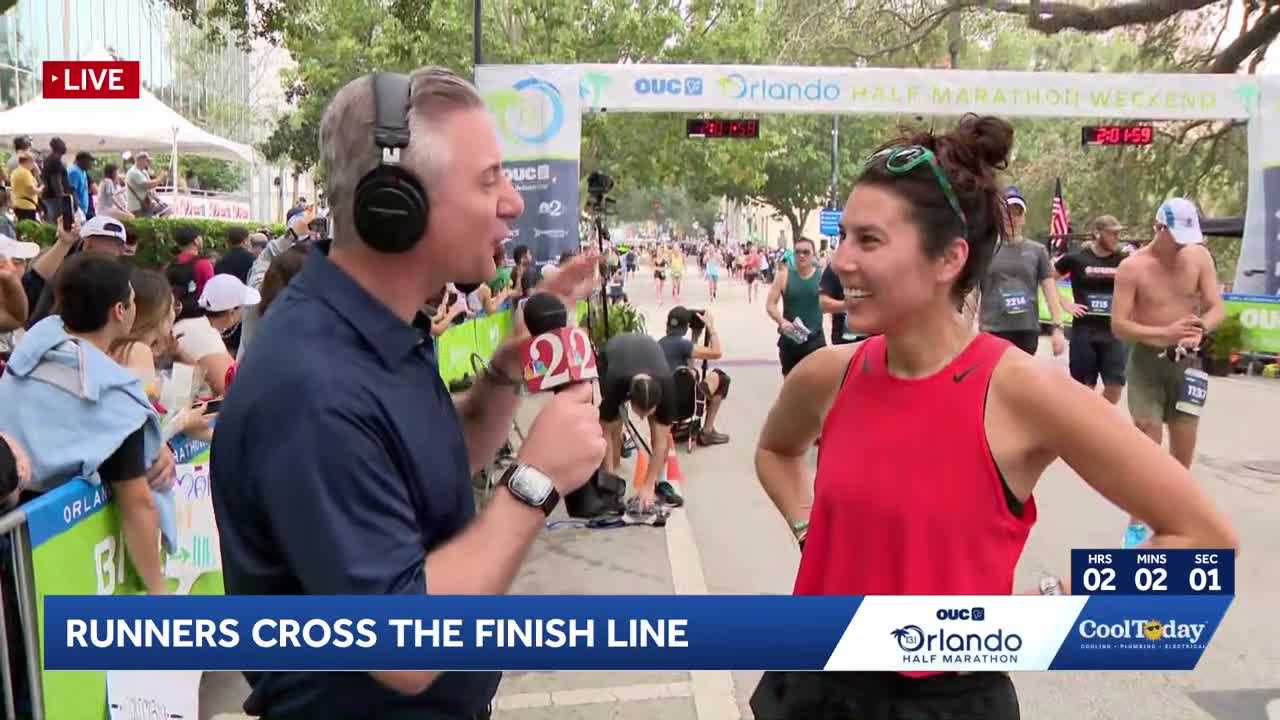 WESH 2ers cross finish line at OUC Orlando Half Marathon