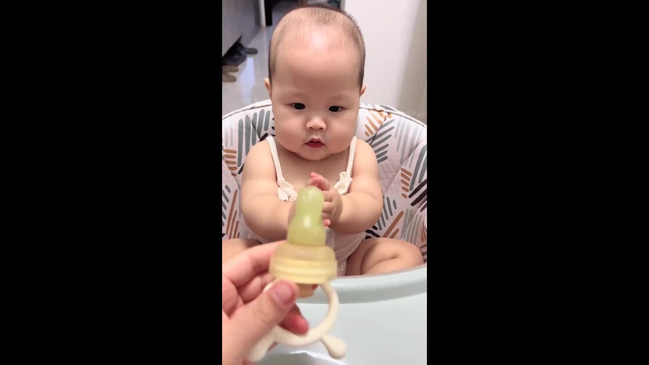 Baby tries fruit feeder for the first time in Liaoning, China