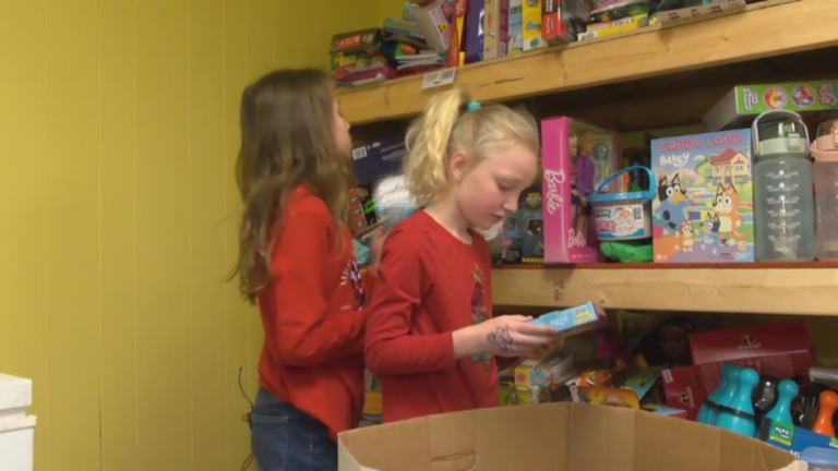 Two sisters stack, pack toys at church for less fortunate kids