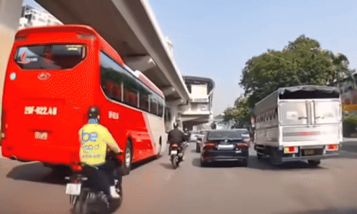 Motorcyclist miraculously escapes death under bus wheel in Hanoi