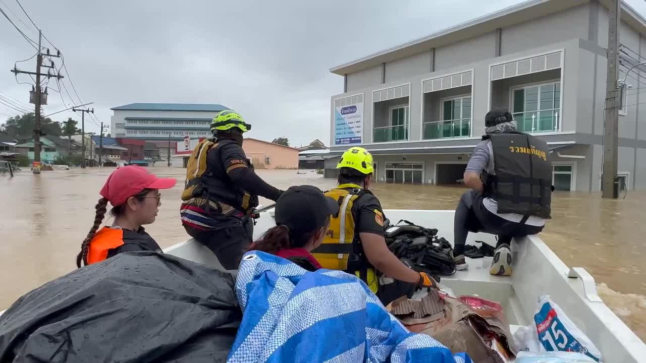 Rescuers row through submerged neighbourhoods to save residents ...