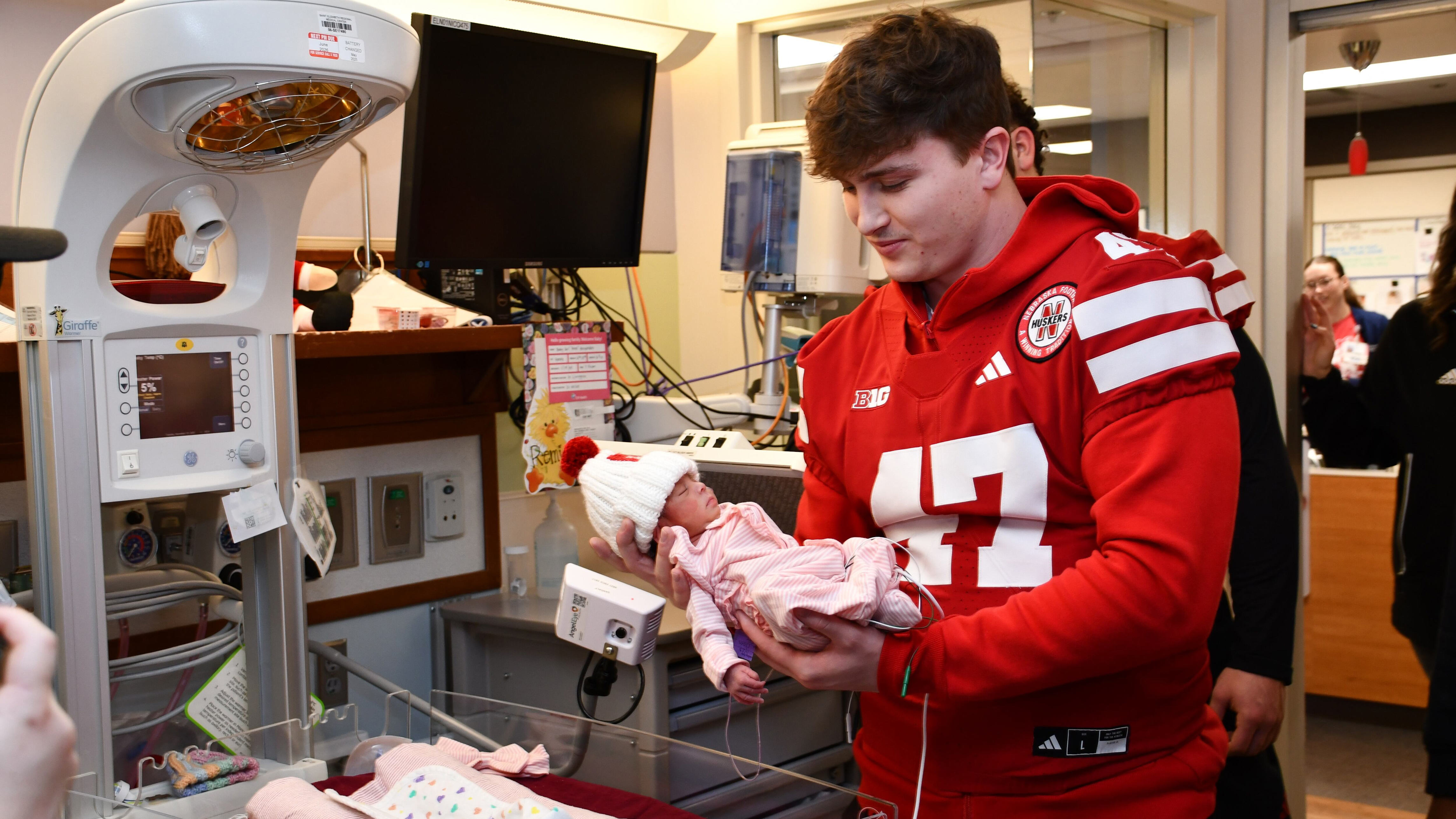 Husker football players bring holiday cheer to hospital patients, families
