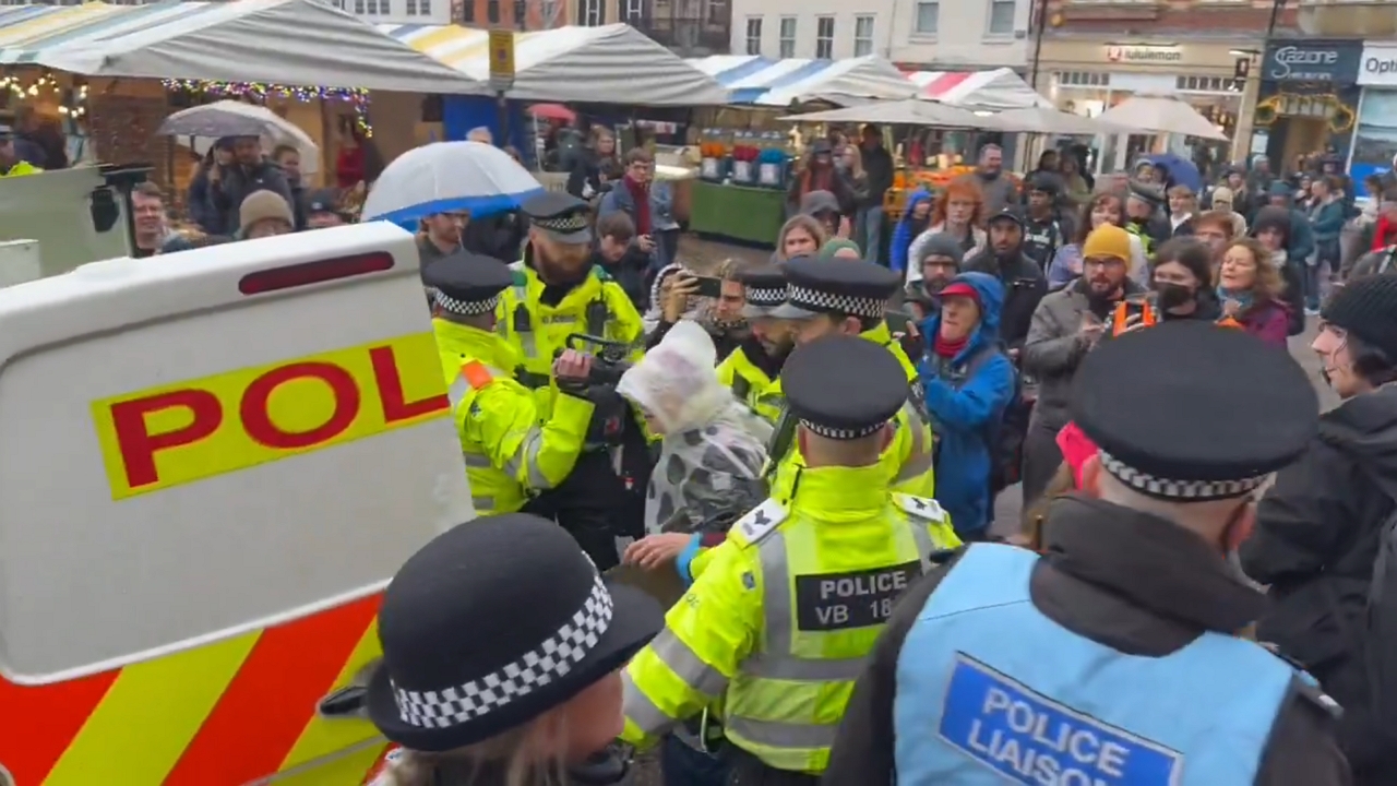 Police detain elderly demonstrators in Market Square in Cambridge, UK