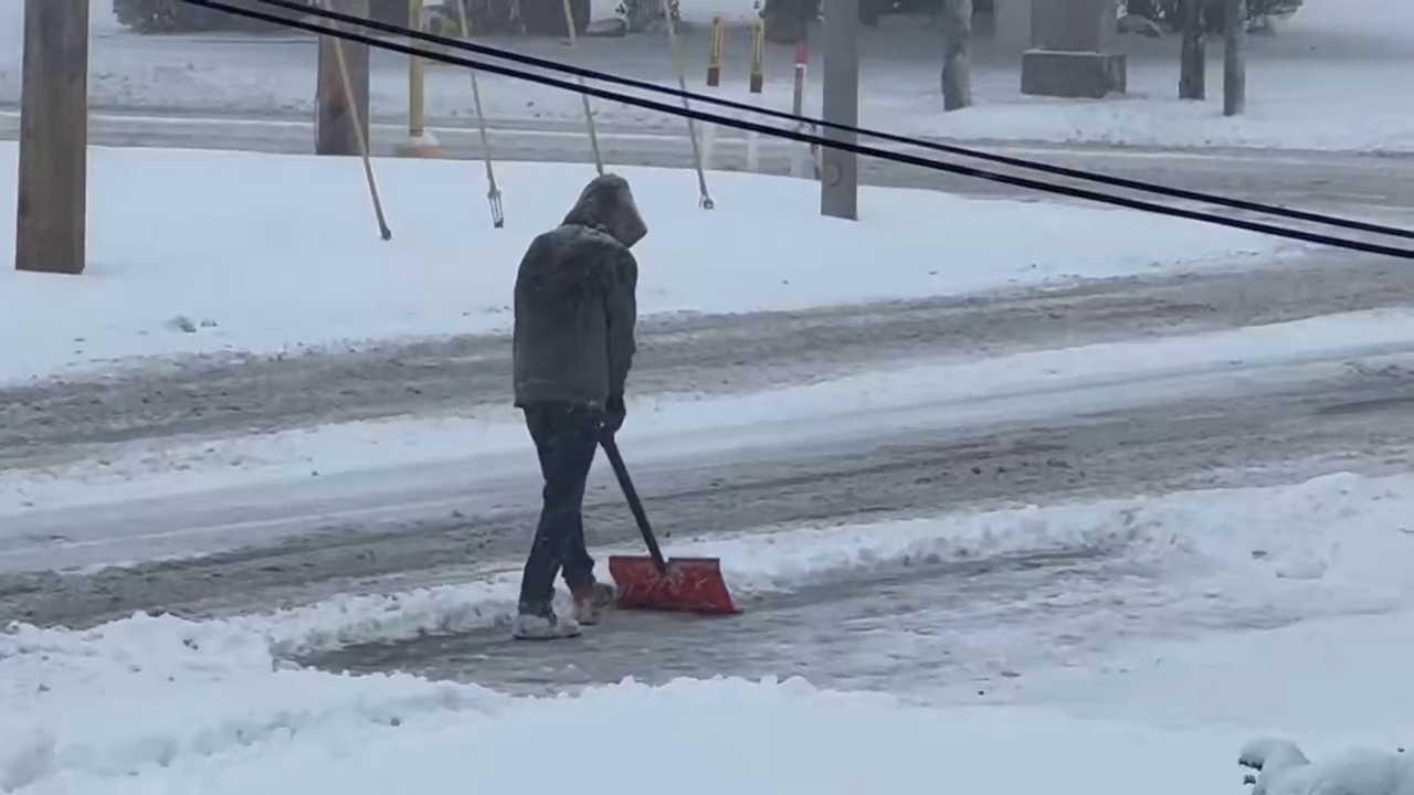 Man clears pathway through heavy snowfall in Highland, Indiana, USA
