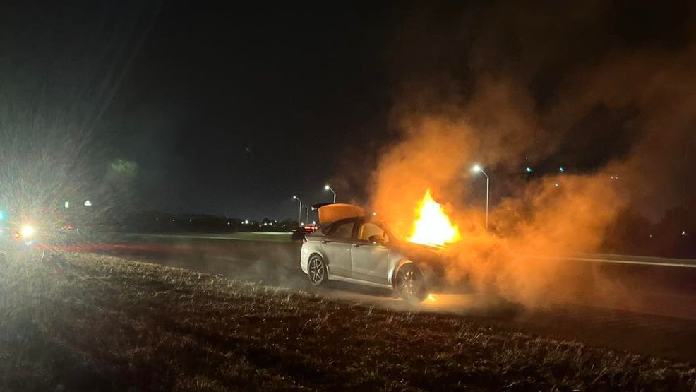 Car damaged after fire reportedly sparks in engine compartment