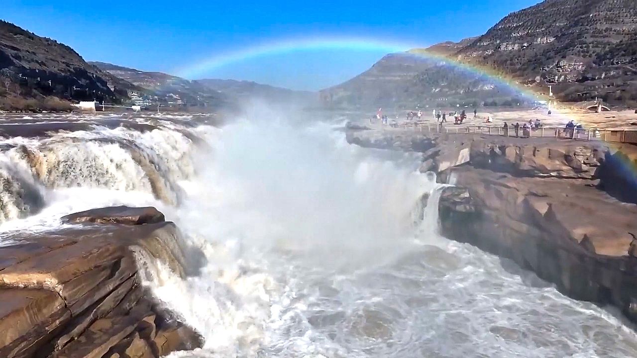 Shimmering rainbow appears over massive waterfall in China