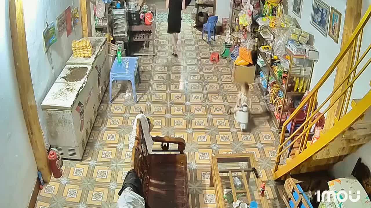 Cheeky toddler fakes falling from toy bike to call over distracted dad