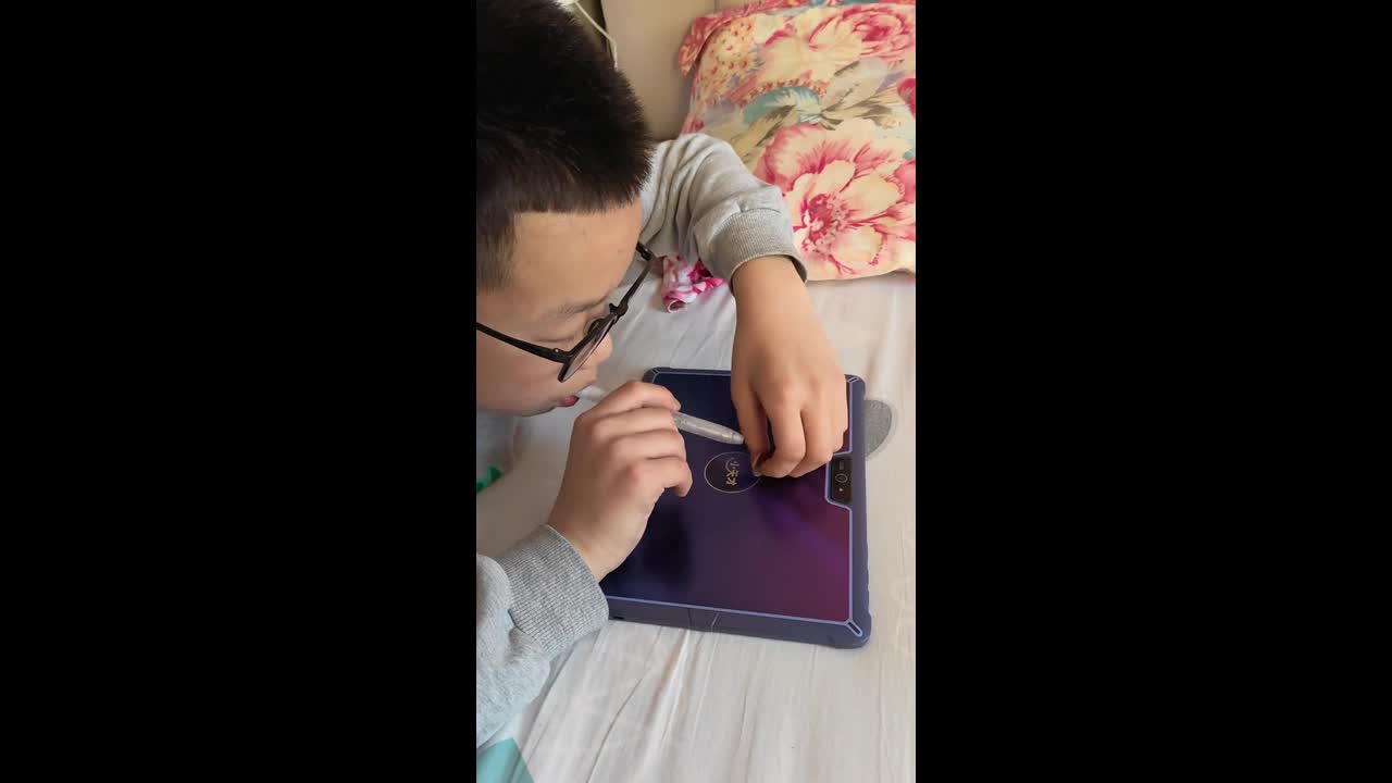 Boy spins coin using stylus on device in Heilongjiang, China