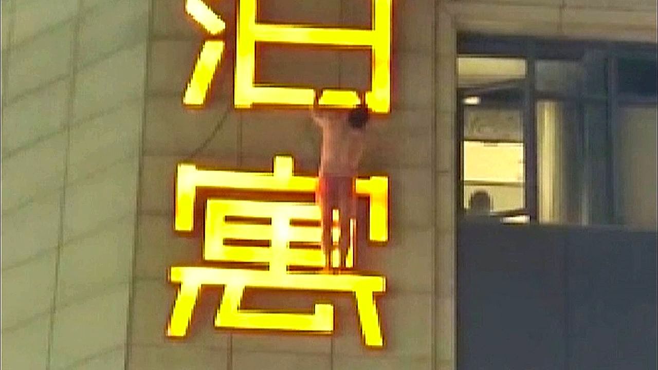 Romeo dangles from hotel sign in his boxers