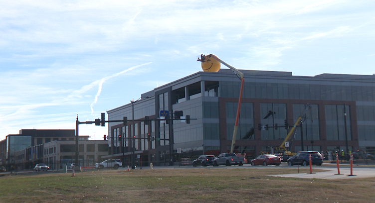 Walmart hoists 16-foot smiley face sculpture on the roof of Sparky Building