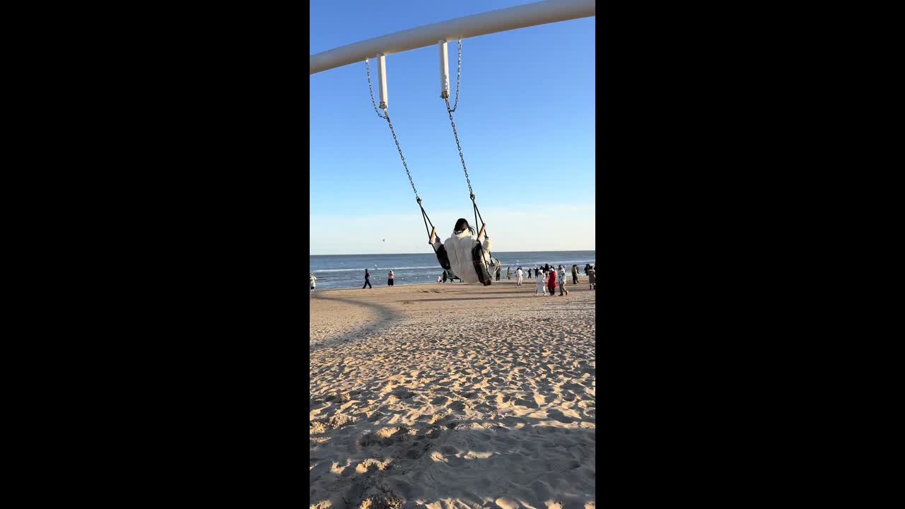 Swing push ends in a sandy fall on a beach in Beijing, China
