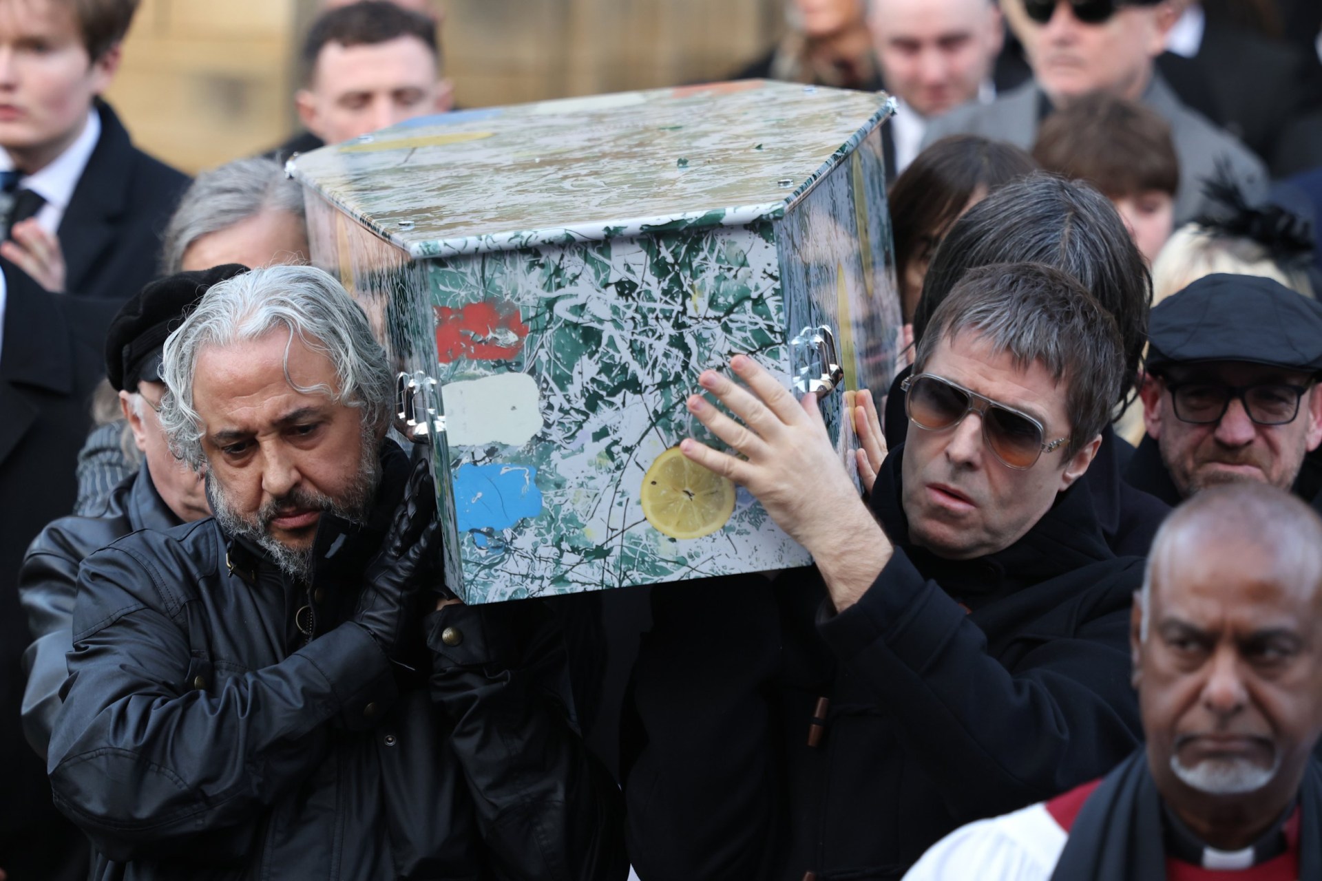 Liam Gallagher carries Gary Mounfield's coffin