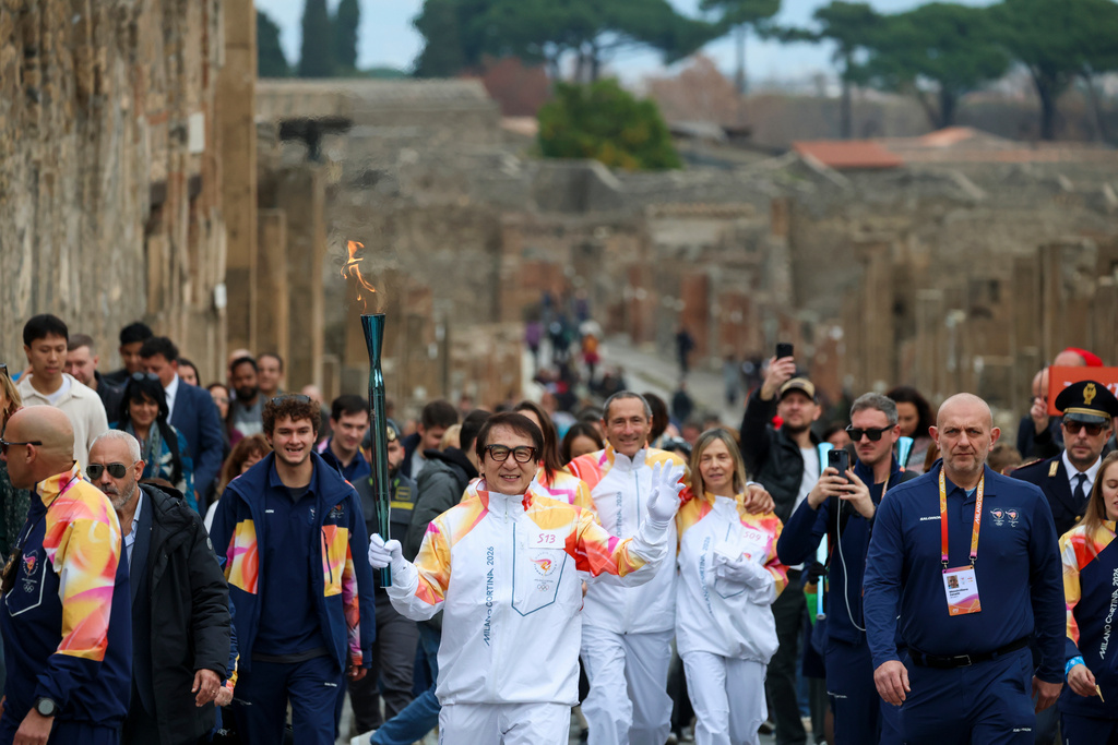 Jackie Chan carries the Milan Cortina Olympic torch through the ruins ...