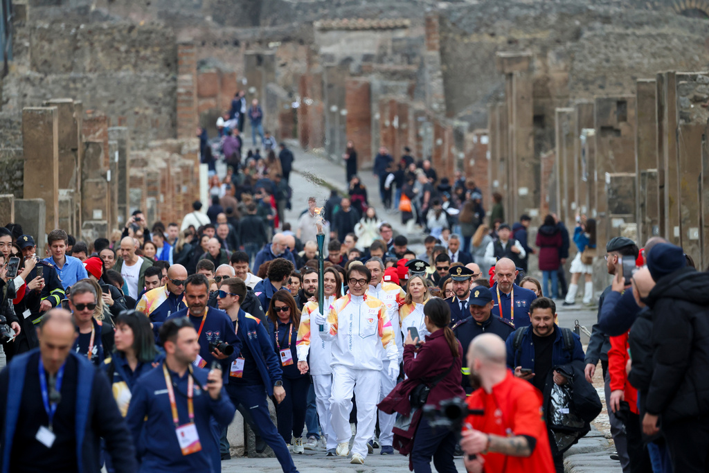 Jackie Chan carries the Milan Cortina Olympic torch through the ruins ...