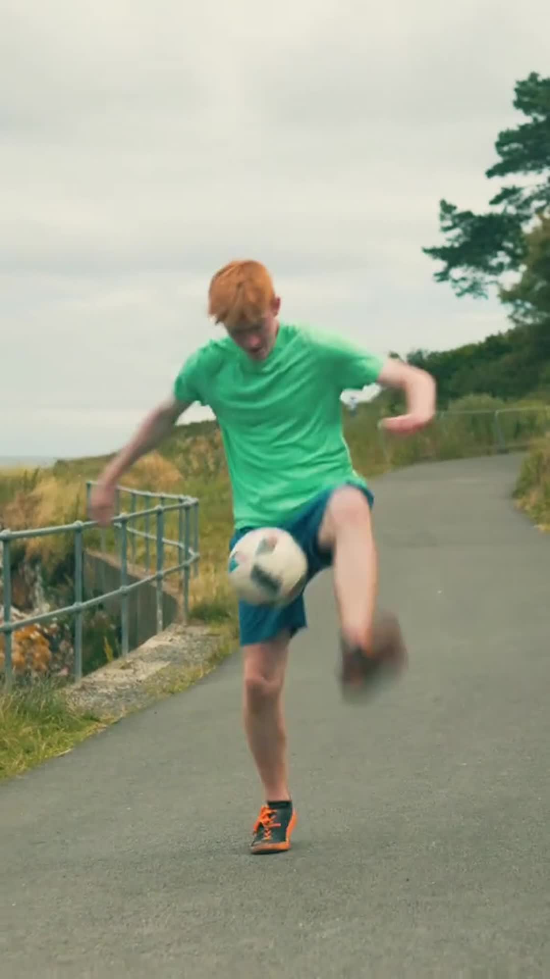 Impressive freestyle football tricks performed on a scenic pathway