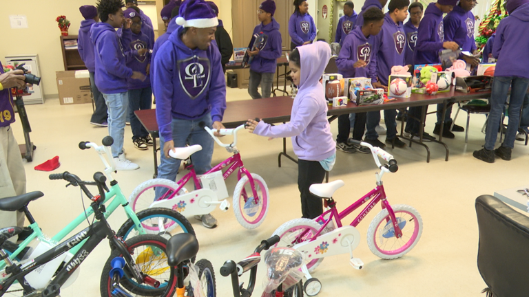 Young men give toys for the holidays