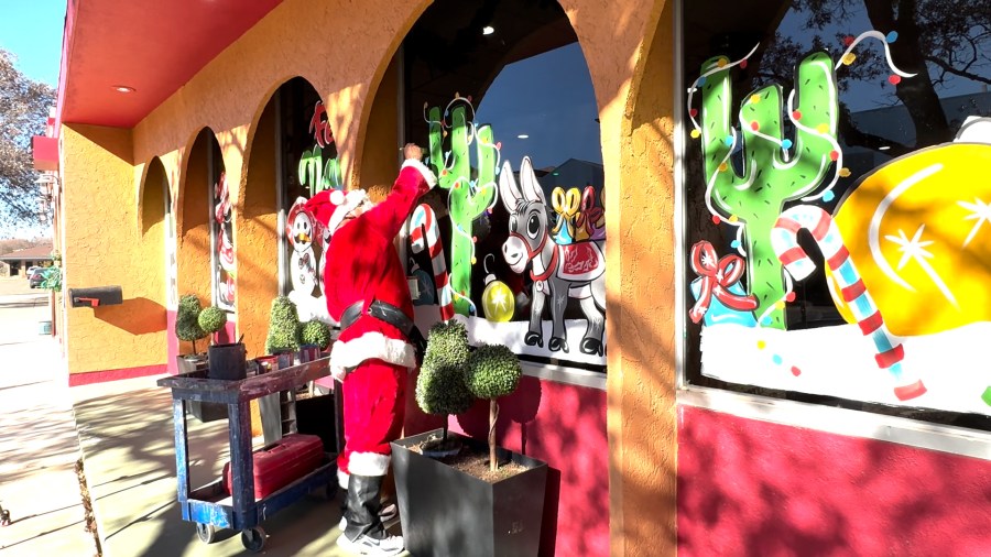 Local artist spreading holiday cheer through window painting