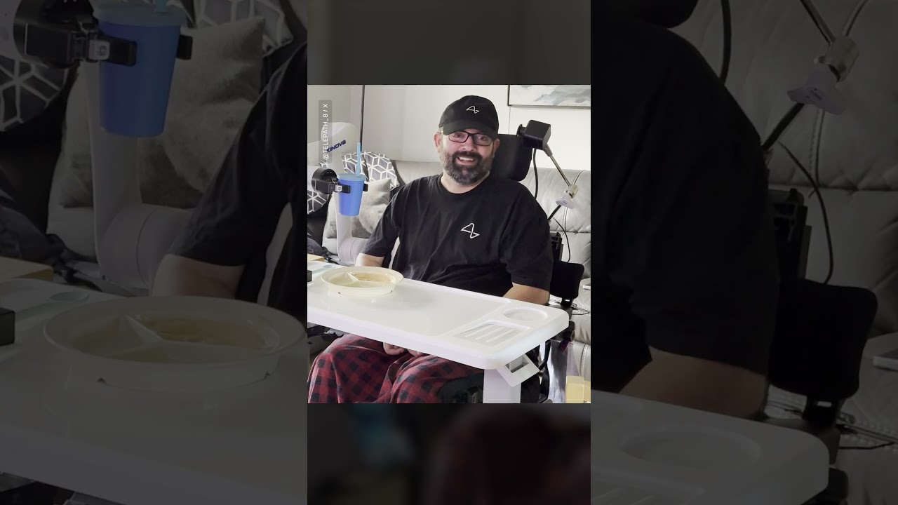 Neuralink user controls a robot arm with hand movements