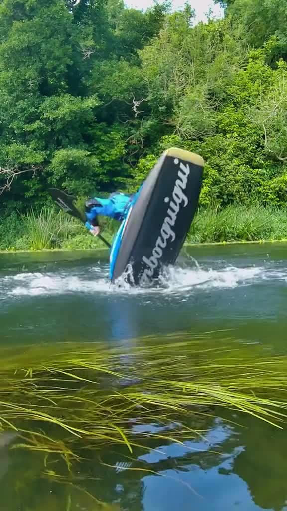 Kayak freestyle flip on a serene river adventure