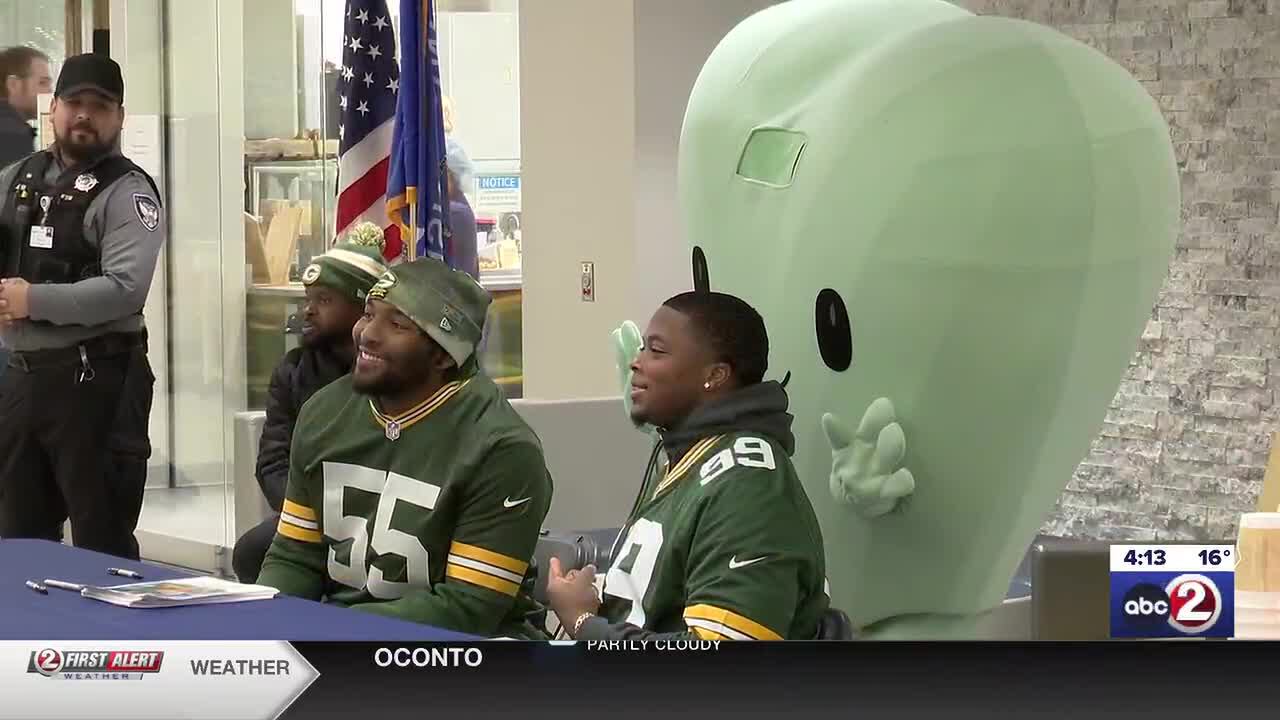 Packer players sign autographs and pose for photos at hospital