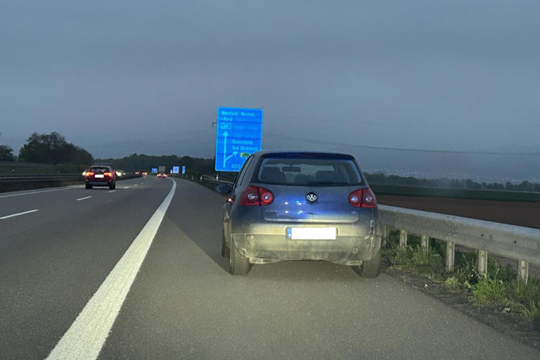Mann parkt seinen VW auf der Autobahn, weil er etwas Wichtiges ...