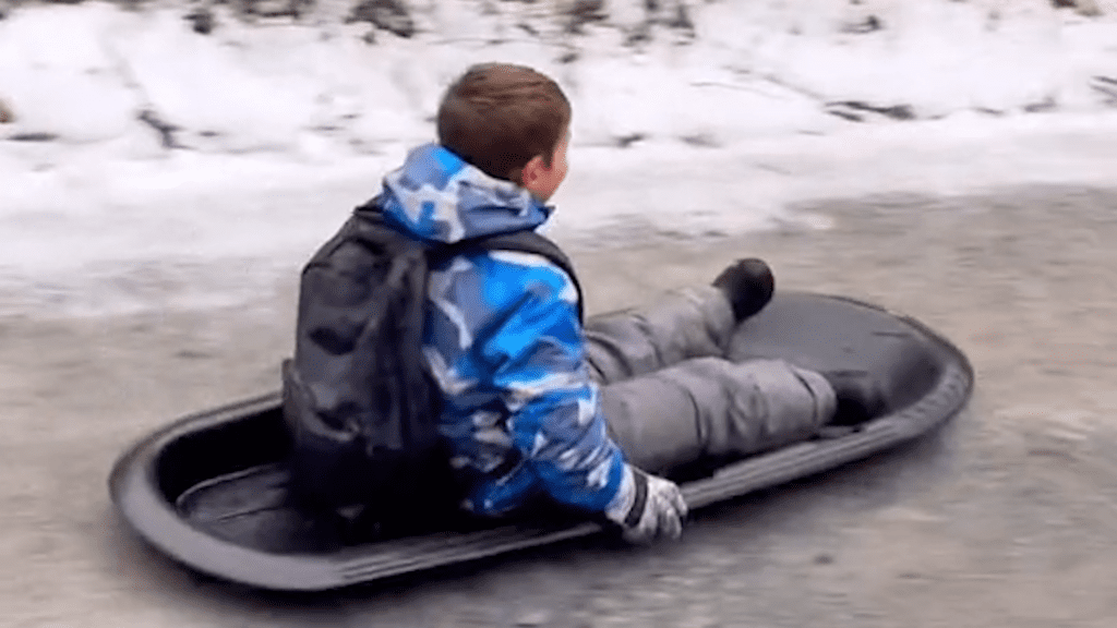 Mum and kids forced to sledge to school during icy conditions