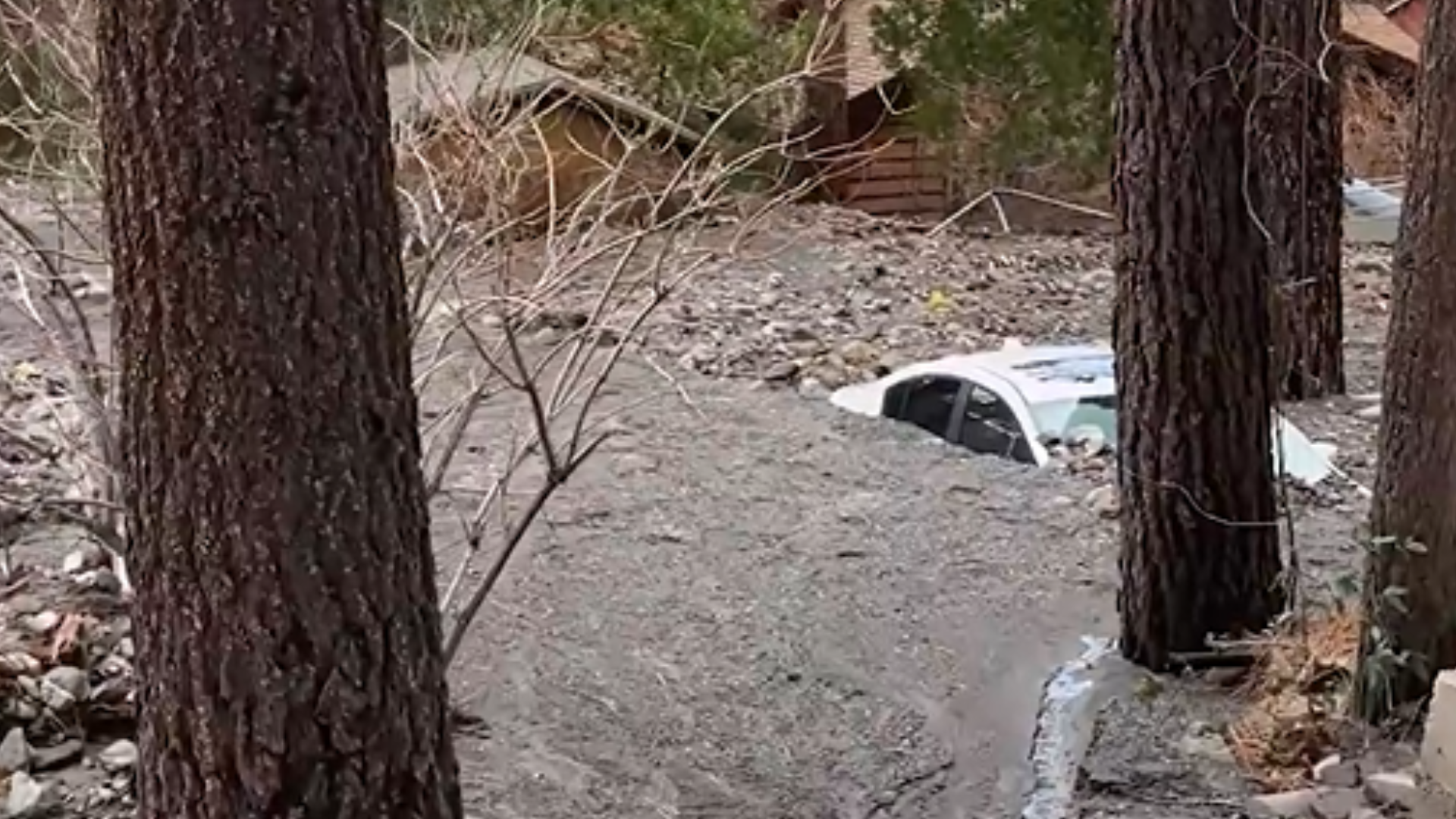 California homes and vehicles buried in muddy debris after flooding
