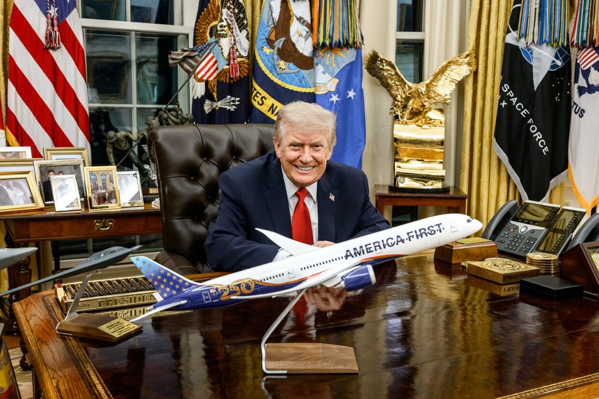 Trump smiles as he shows off model of 'America First 250' plane