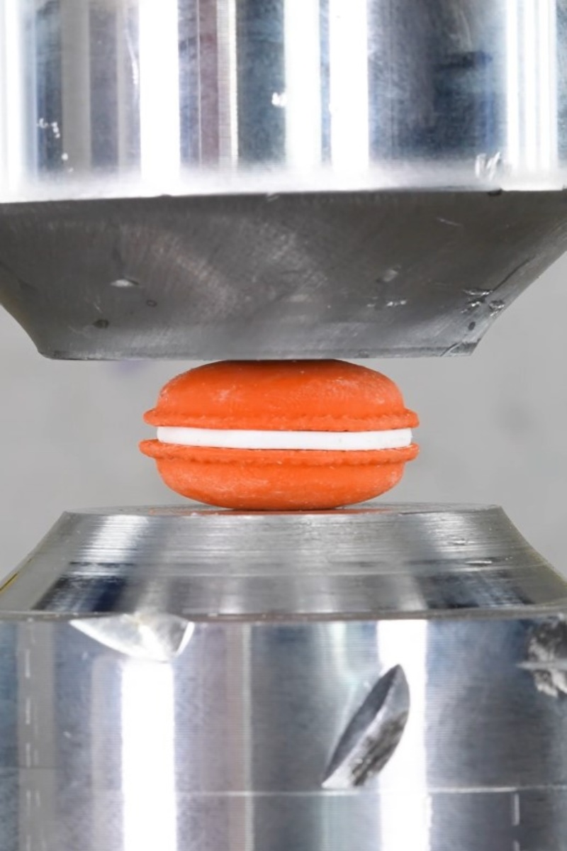 Aplastando un macaron de naranja bajo una prensa hidráulica