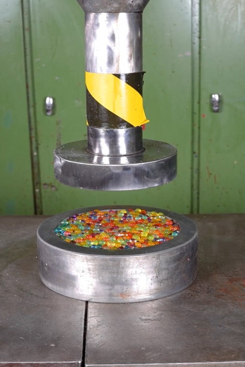 Broyer des Orbeez colorés sous une presse hydraulique