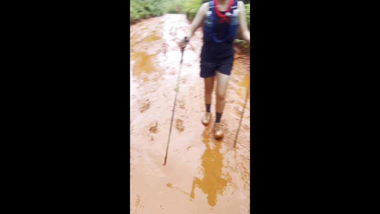 Hikers battle through thick 'milk tea' mud as they climb hillside