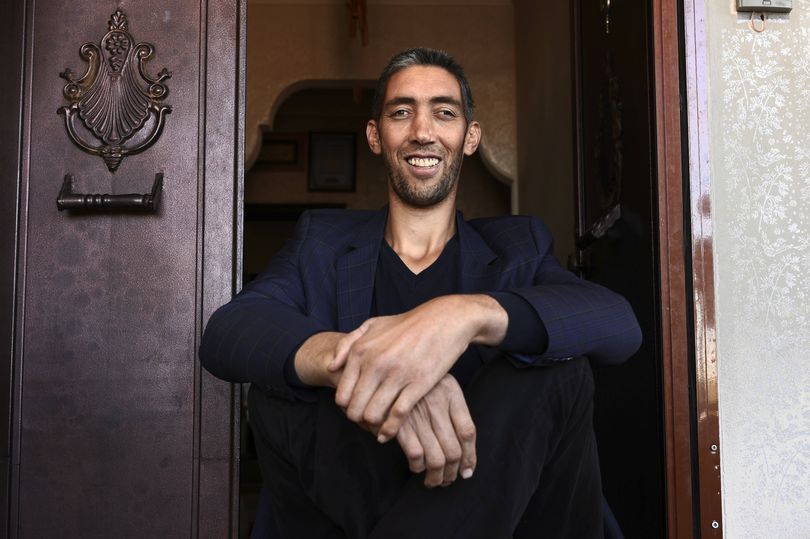 World's tallest man who stands at 8ft 2in needs three beds and travels ...