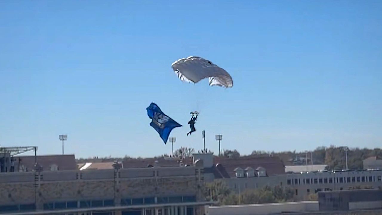 Paratrooper crashes into field goal during packed football game