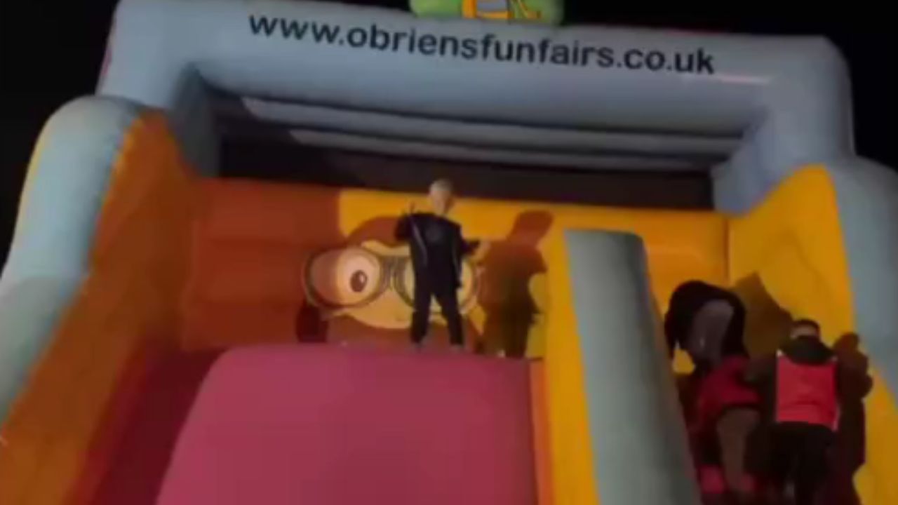 Little boy runs on bouncy castle at fireworks display and meets a fall