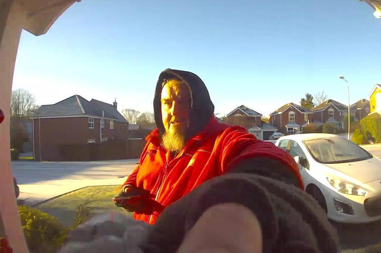 Moment postman’s trolley skated down icy road while his back was turned