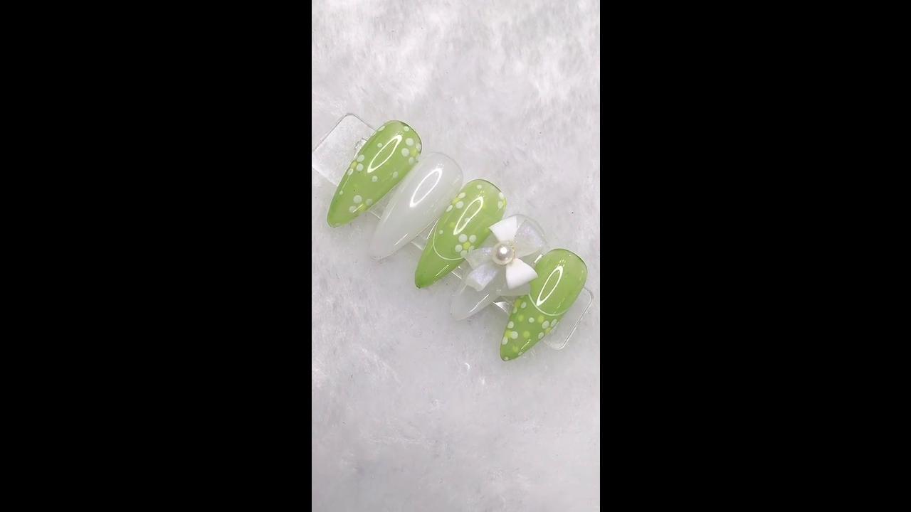 Creating nail art with polka dot motifs in fresh green and white colors