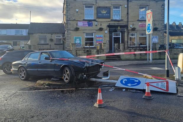 Dramatic images after 'smoking' car smashes into signpost outside pub