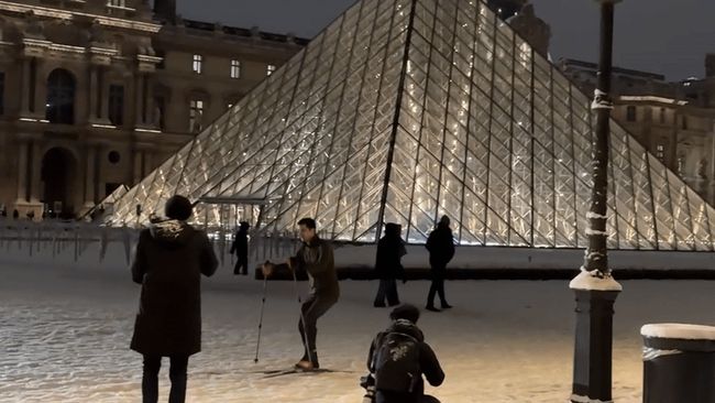 Parisian skis past the Louvre as snow covers French capital