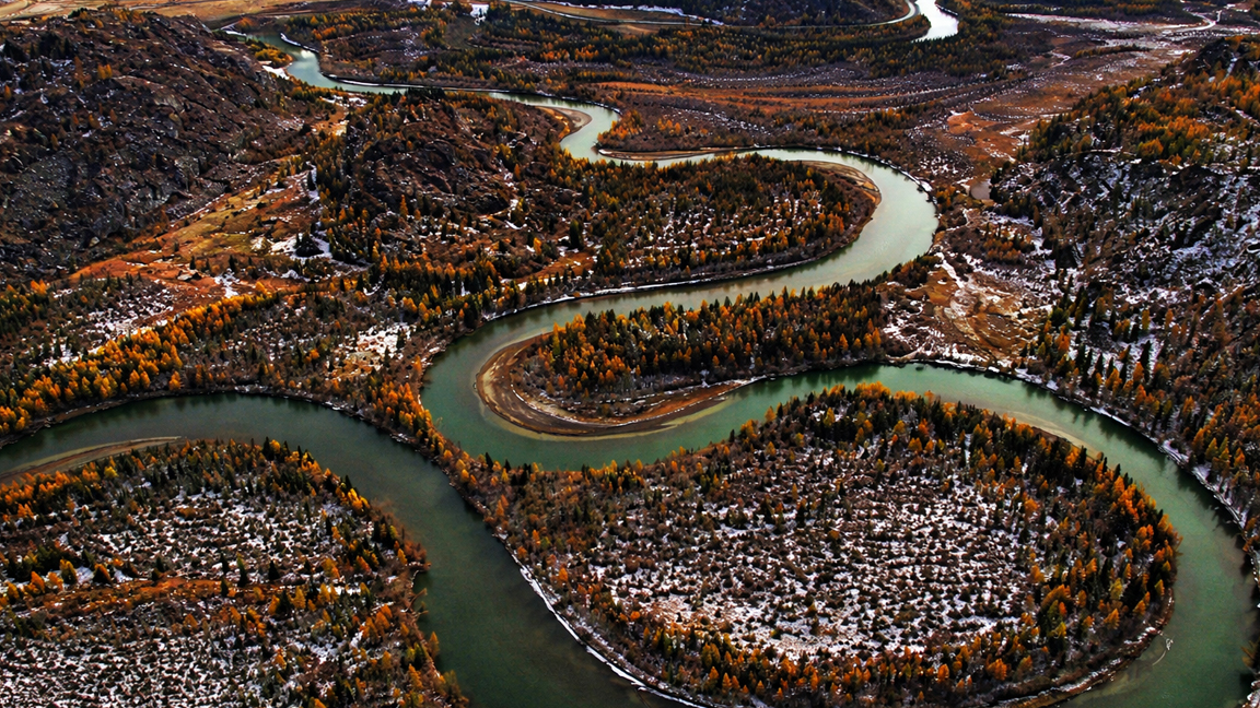 Winding river through forested valleys