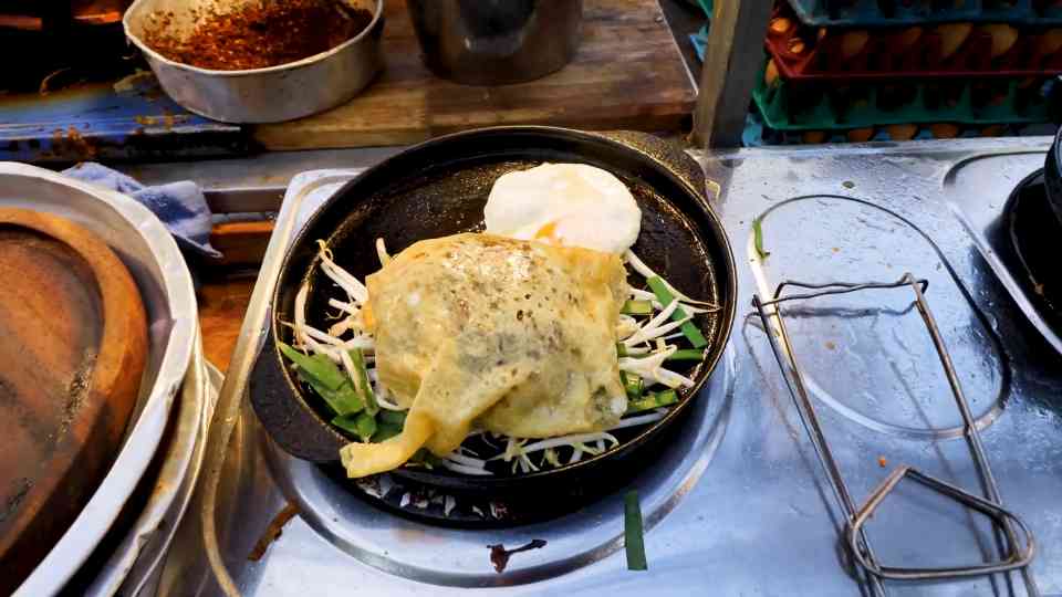 A cowboy hat, a hot wok, and Bangkok’s most famous noodles